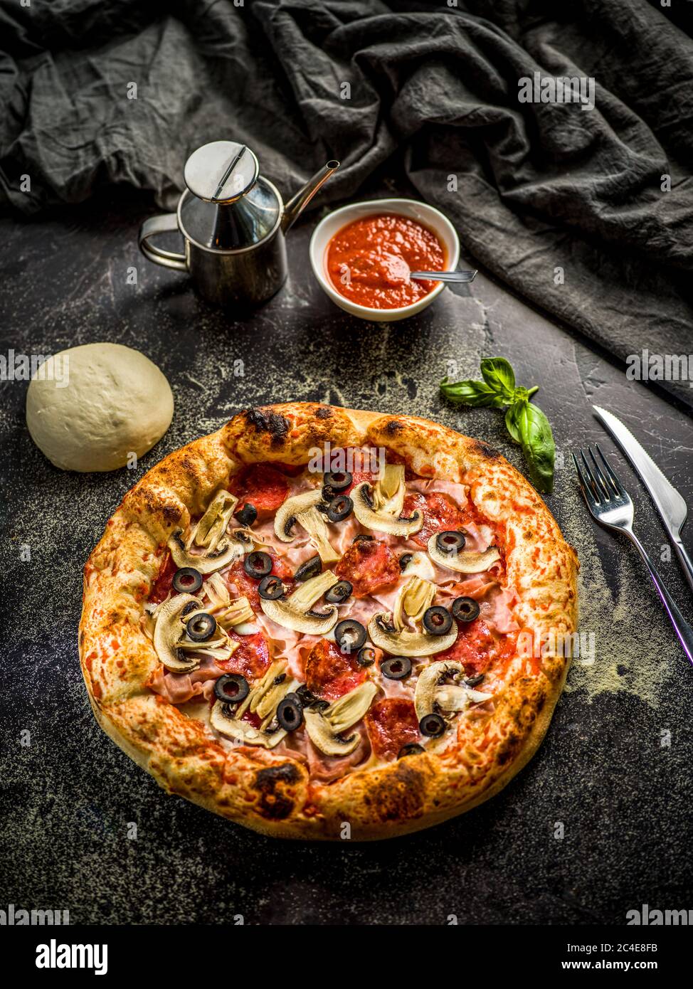 Pizza on a table with ingredients Stock Photo - Alamy