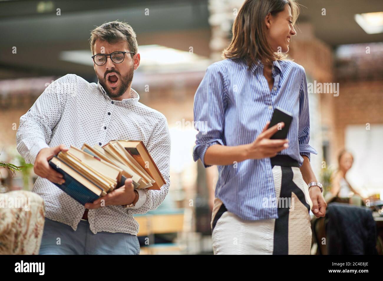 old-fashioned man carrying heavy pile of books that about to fall from ...