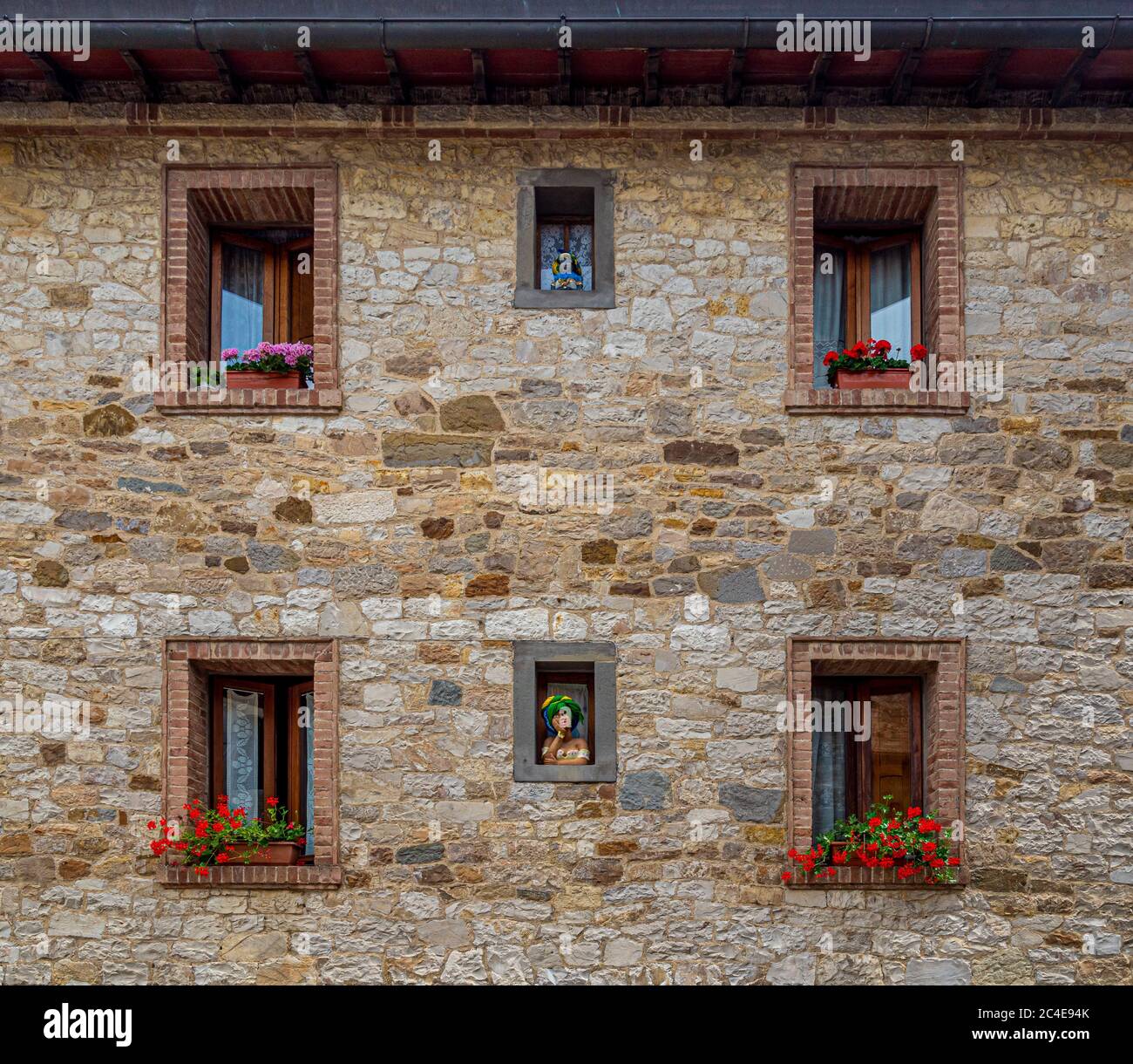 Window boxes and statues on a building in Castellina in Chianti ...