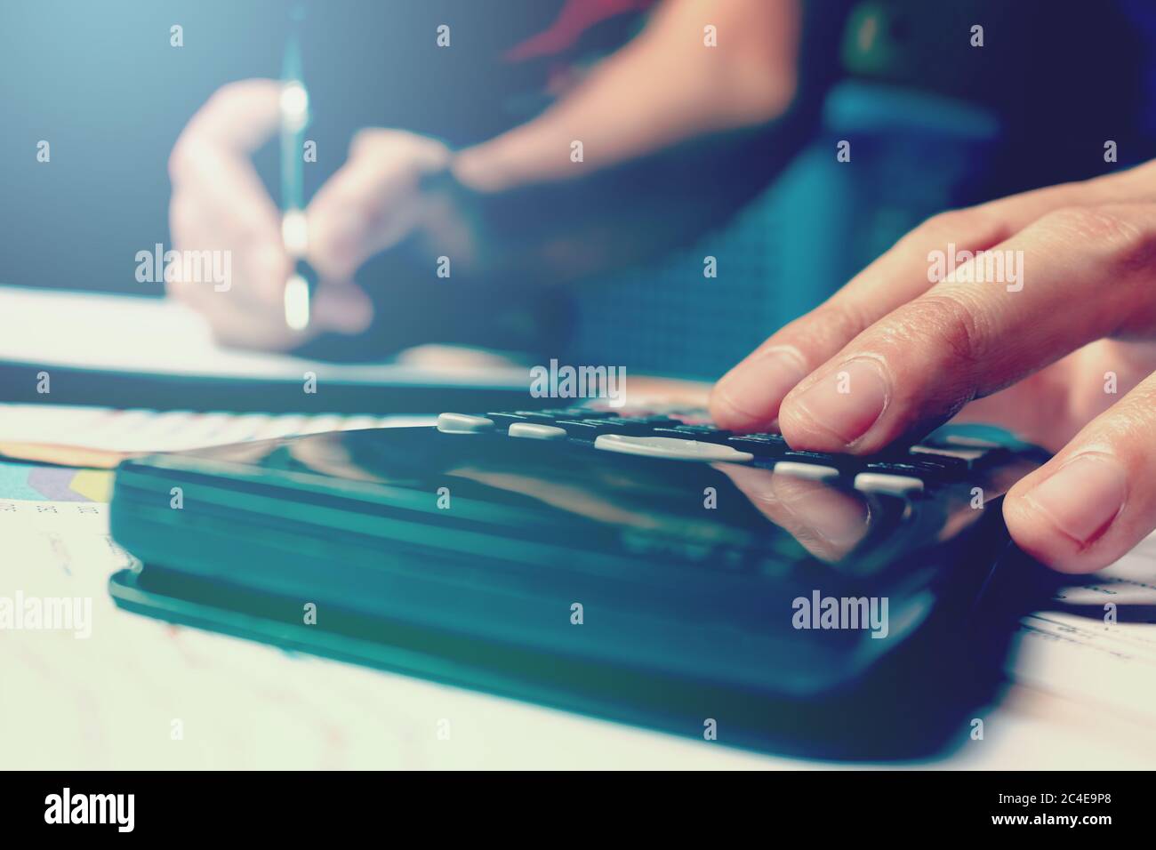 Calculator with woman hand typing and writing make note and doing ...