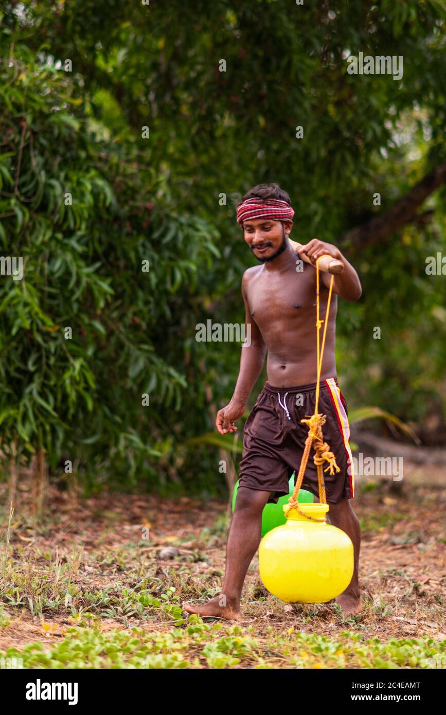 GOA, INDIA - May 14, 2020: Local Indian native/farmer watering a ...