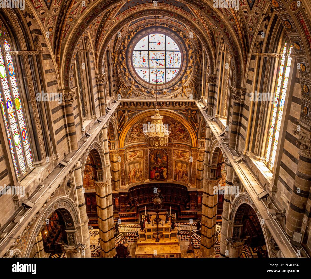 Ornate ceiling and circular window above the high altar in Siena ...