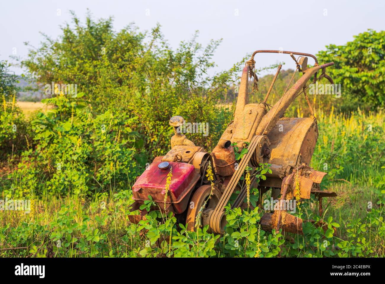 Vertical shot of rusty farm equipment in an abandoned field under the ...
