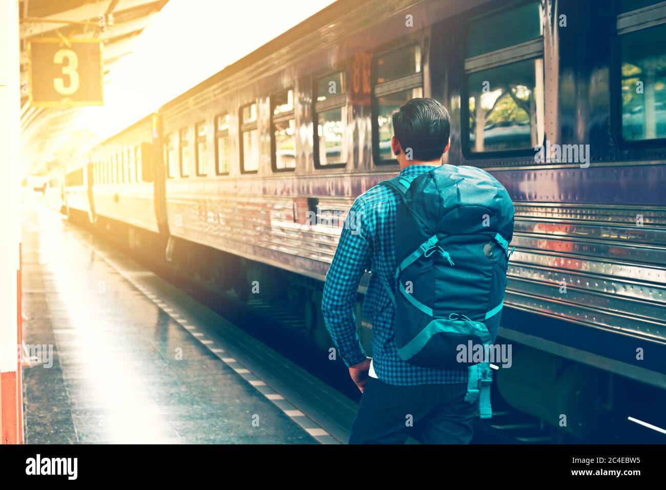 Behind asian young man standing and waiting train on platform Stock ...