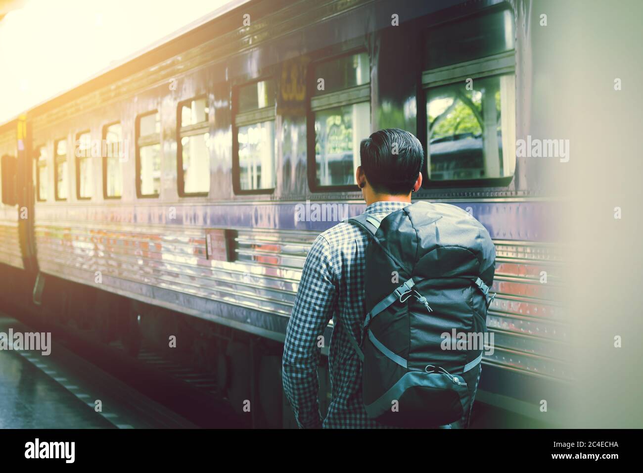 Behind asian young man standing and waiting train on platform Stock ...