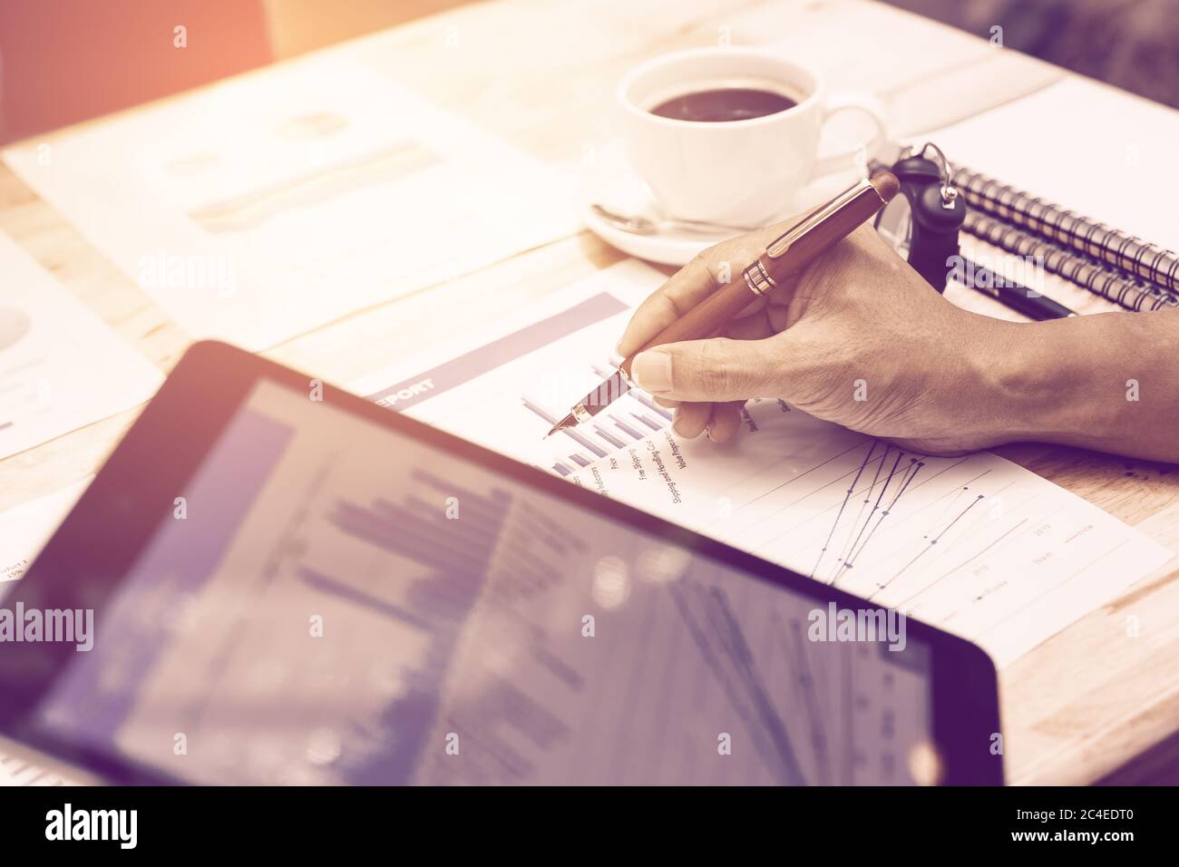 Hand businessman pointing on summary chart report and holding tablet ...