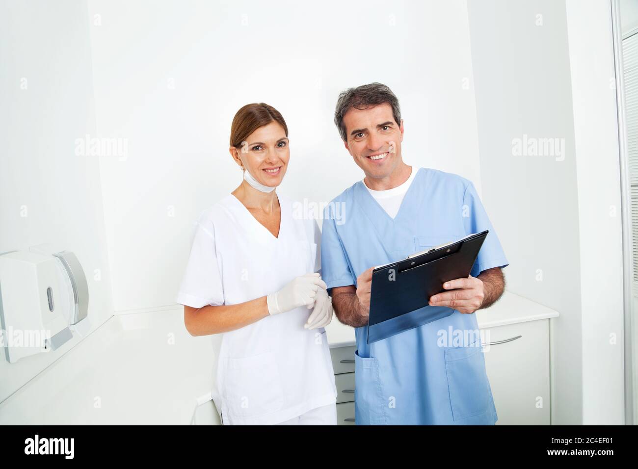 Two smiling doctors with clipboards look at the camera Stock Photo - Alamy