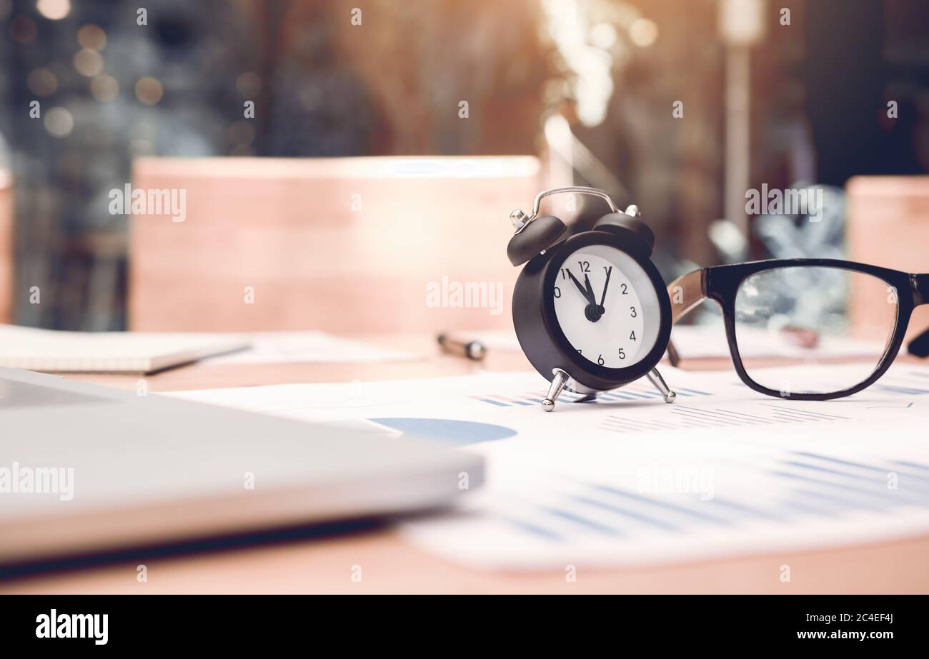 Clock on desk office room Stock Photo - Alamy