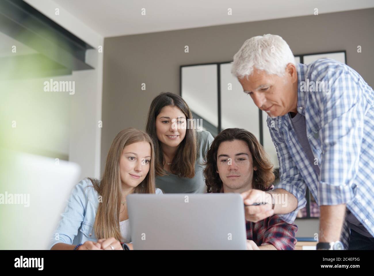 group of students working with a teacher Stock Photo - Alamy