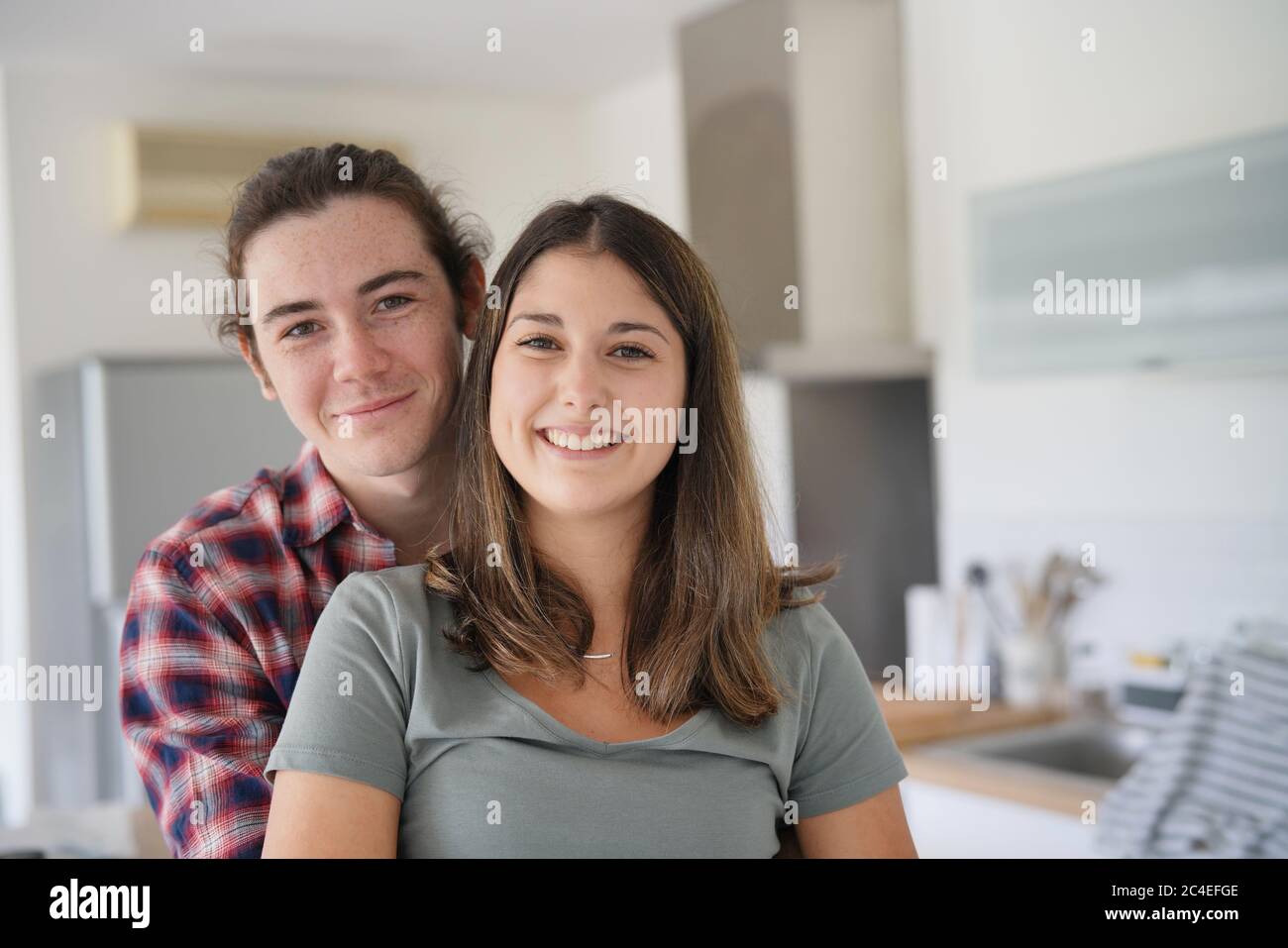 young couple smiling facing camera Stock Photo - Alamy