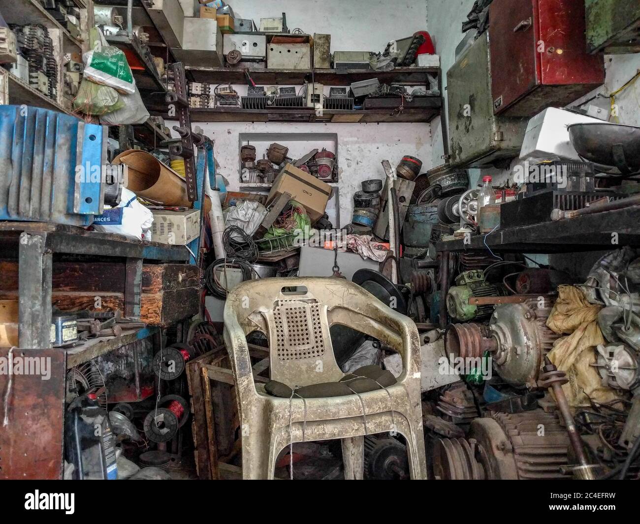 Landscape shot of plastic chairs in the middle of metal mechanic junk ...