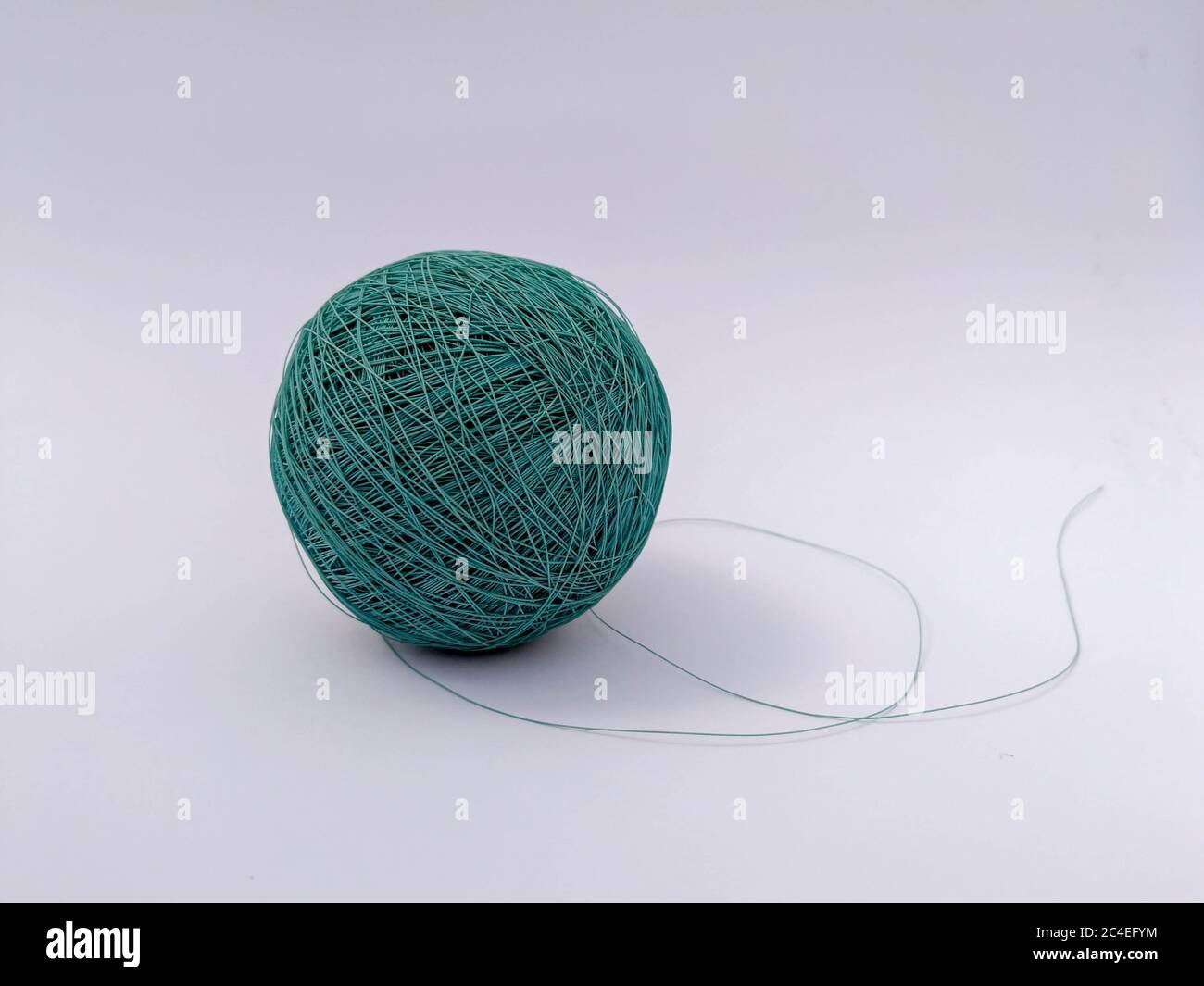 Selective focus shot of a turquoise thread yarn isolated in a white ...