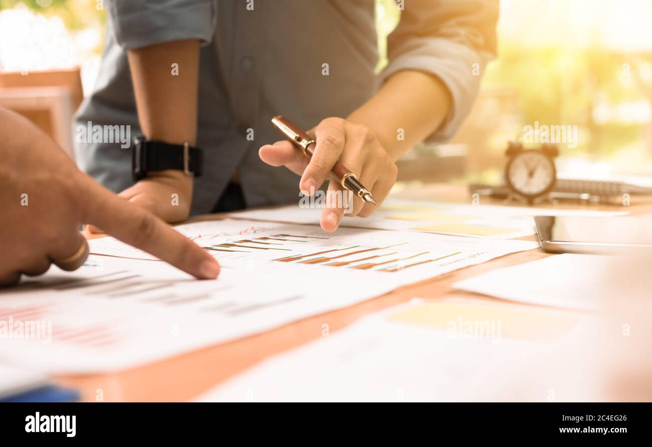 Two business people discussing paperwork summary report in office room ...