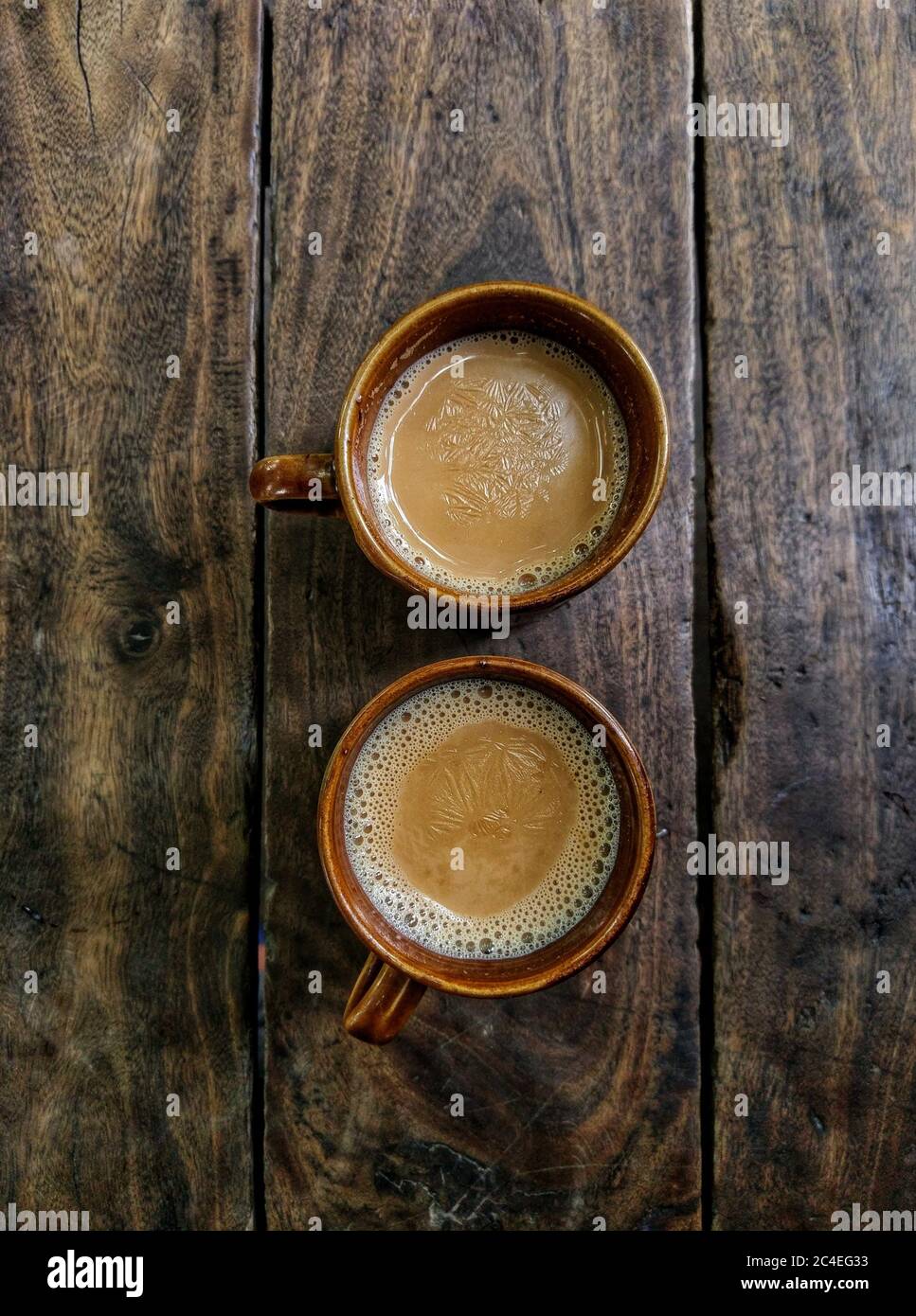Top view of two cups of coffee in brown mugs on a wooden table Stock ...