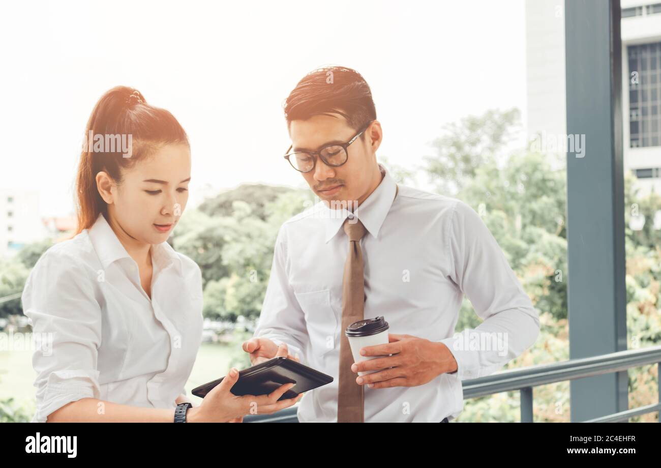 Two couple asian professional coworkers using a digital tablet together ...