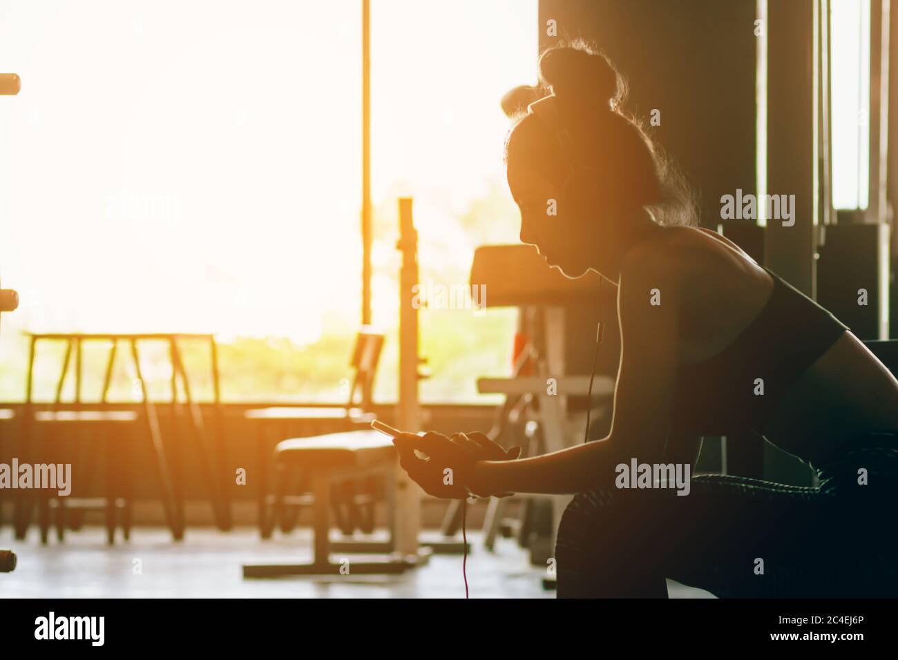 Healthy woman relaxing after exercise and listen music after the ...