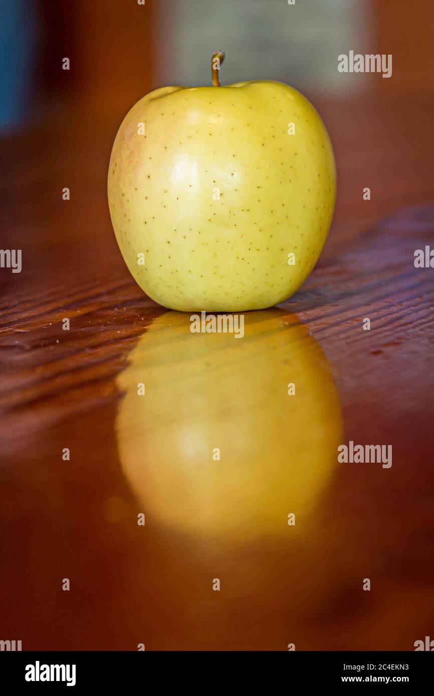 An apple with its reflection in a table Stock Photo - Alamy