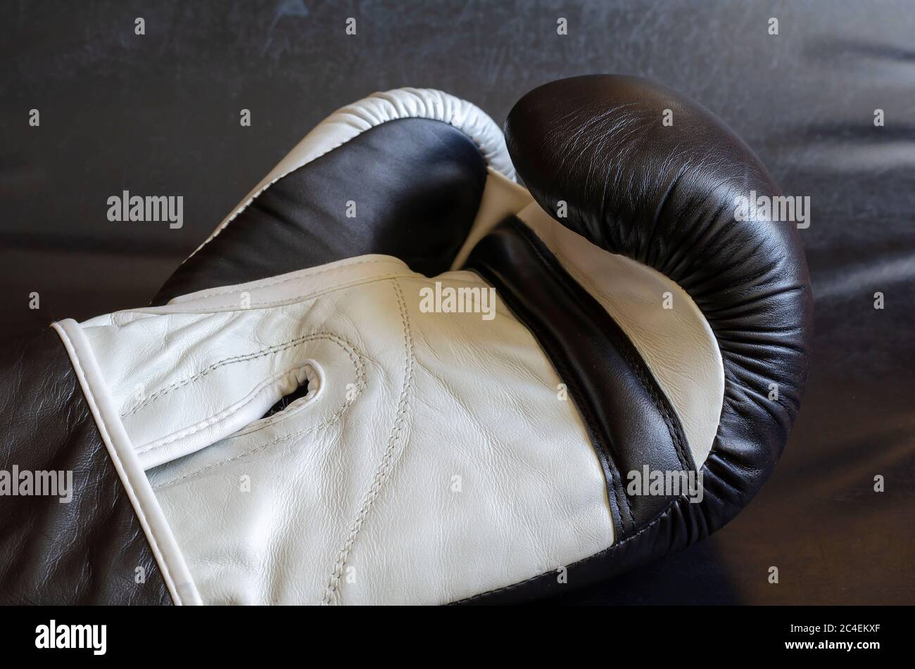 Boxing glove lies on the black floor of the ring. Black and white ...