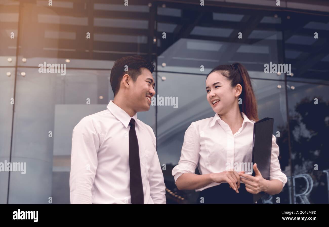 Two business people talking together at office building Stock Photo - Alamy