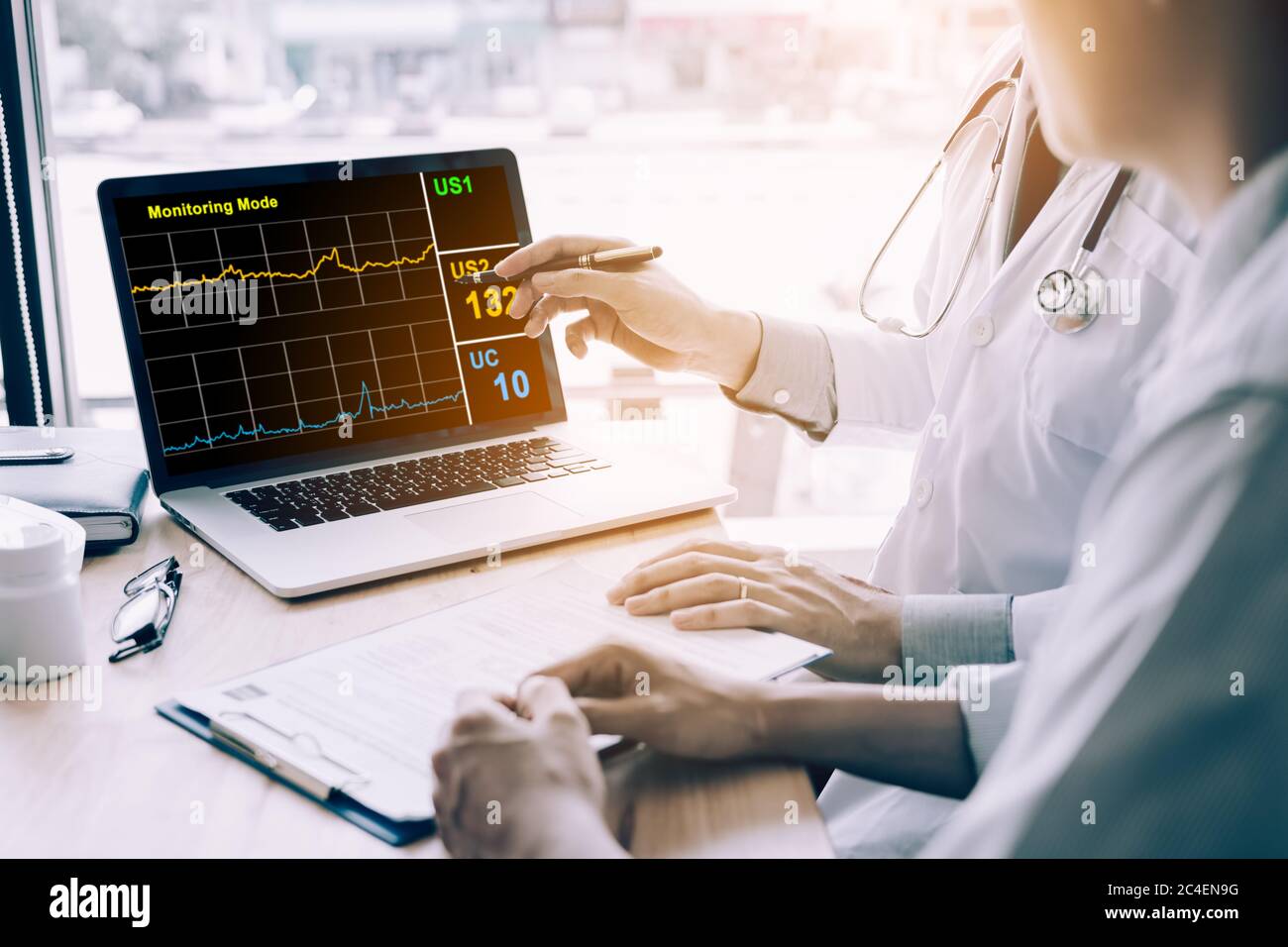 Doctor hand holding pen pointing on laptop screen and talking to the ...