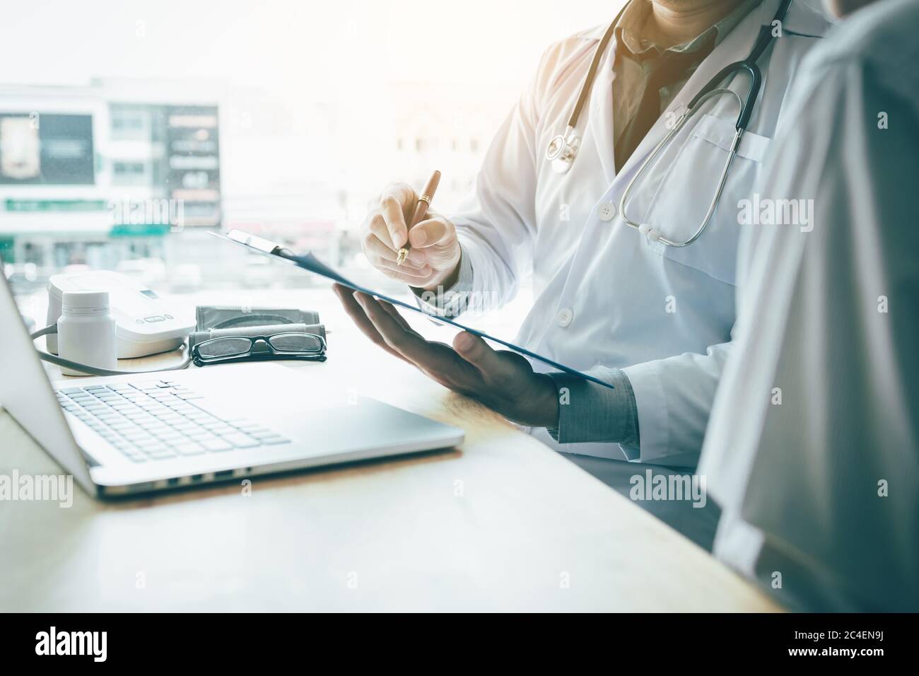 Doctor hand holding pen writing patient history list on note pad and ...