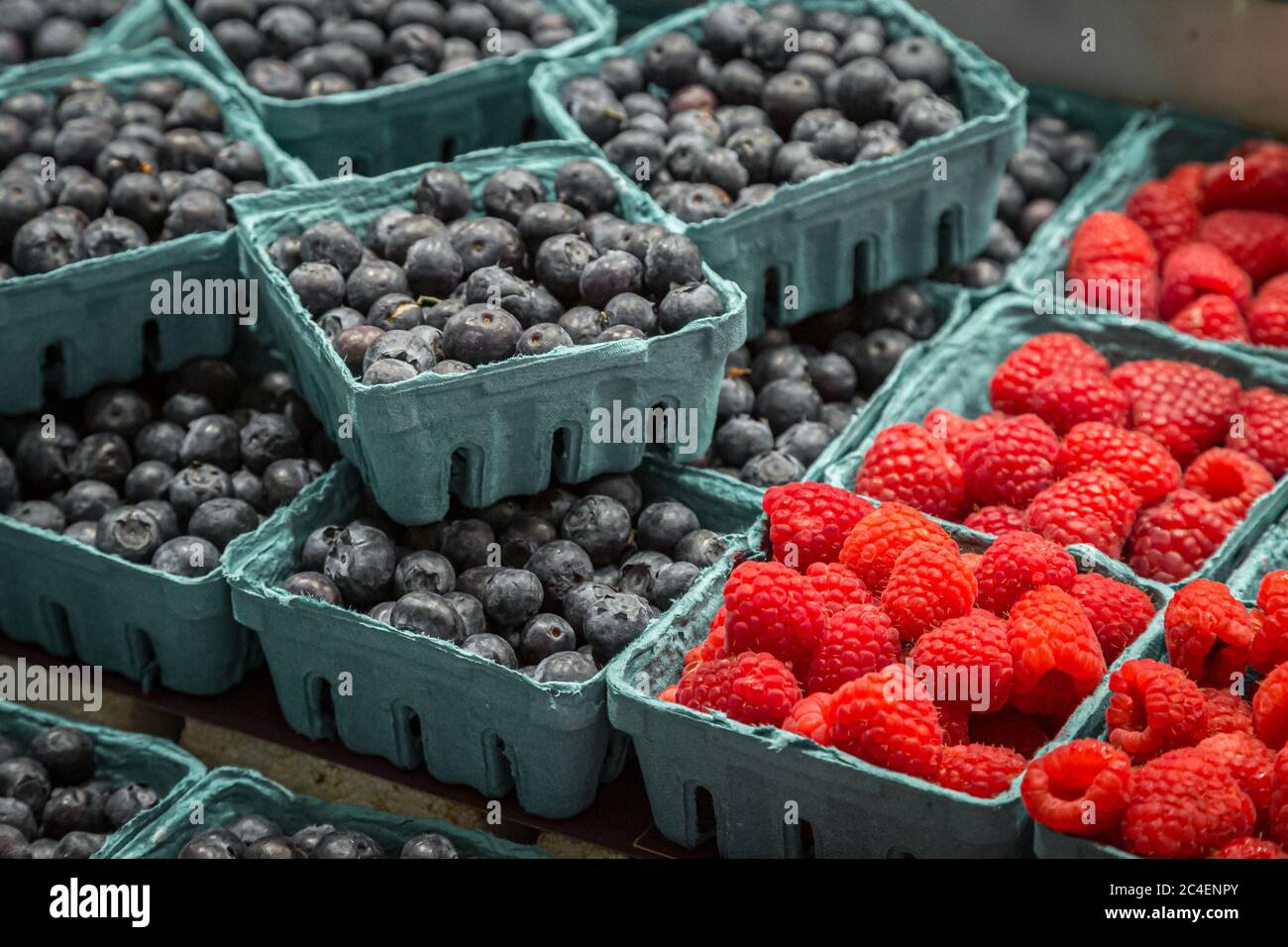 Punnets of raspberries and blueberries for sale on a market stall Stock ...