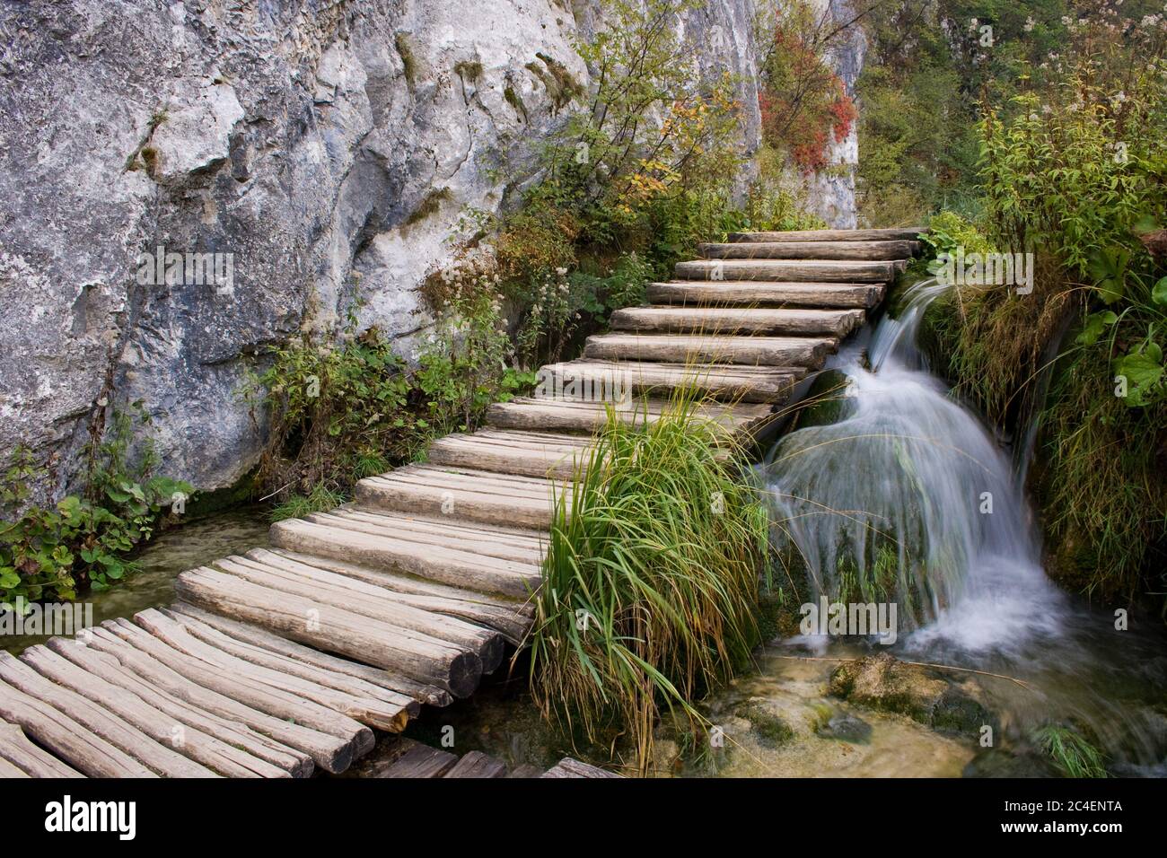 wooden pathway between a small waterfall and a cliff Stock Photo - Alamy