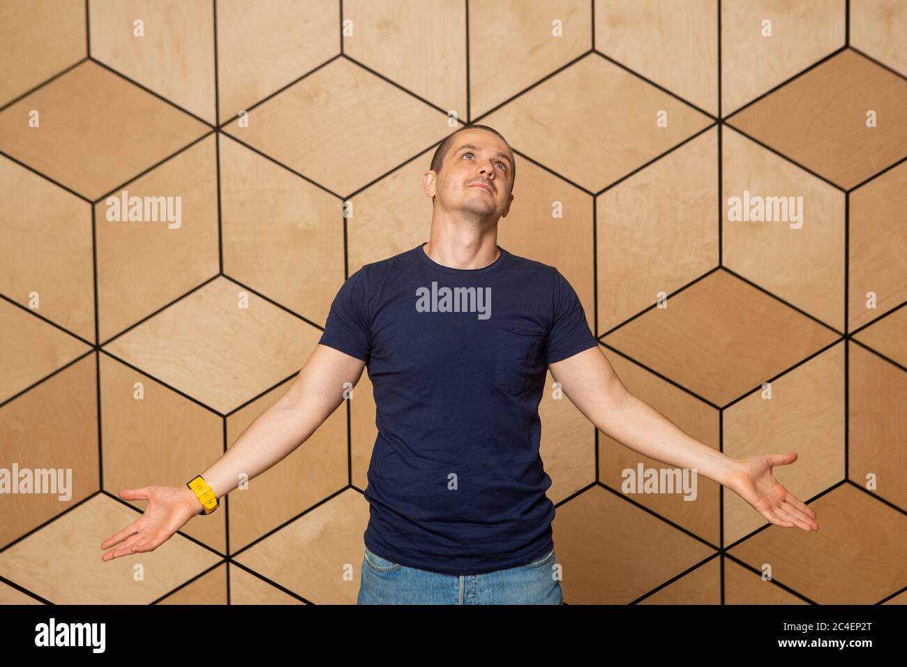 Man as a saint pose at wooden background Stock Photo - Alamy