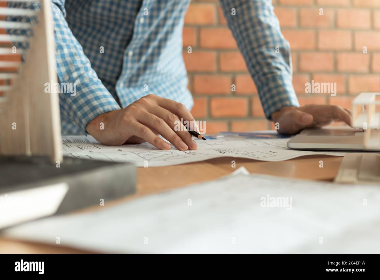 Close up hand engineering man standing examining working on blueprint ...