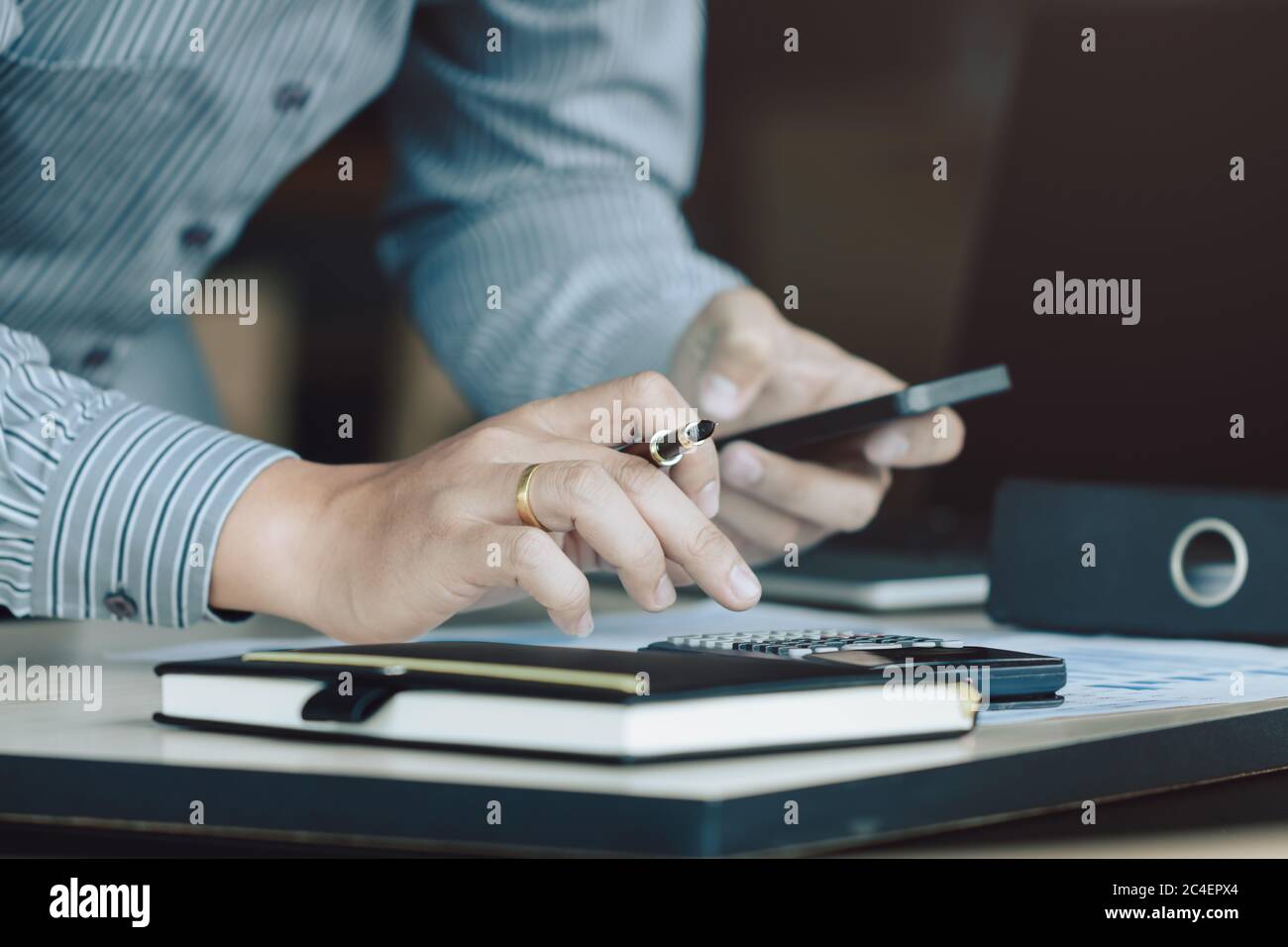 Man holding pen and calculate and making note at office Stock Photo - Alamy