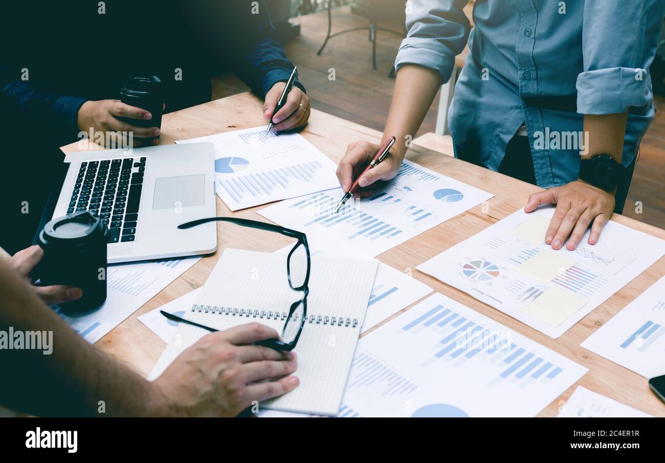 People discussion about graph on desk in office room Stock Photo - Alamy