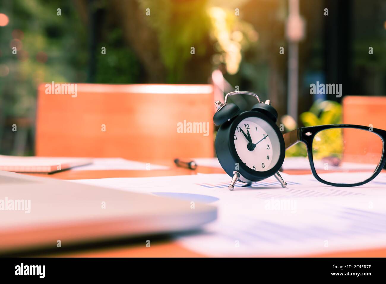 Clock on desk office room Stock Photo - Alamy