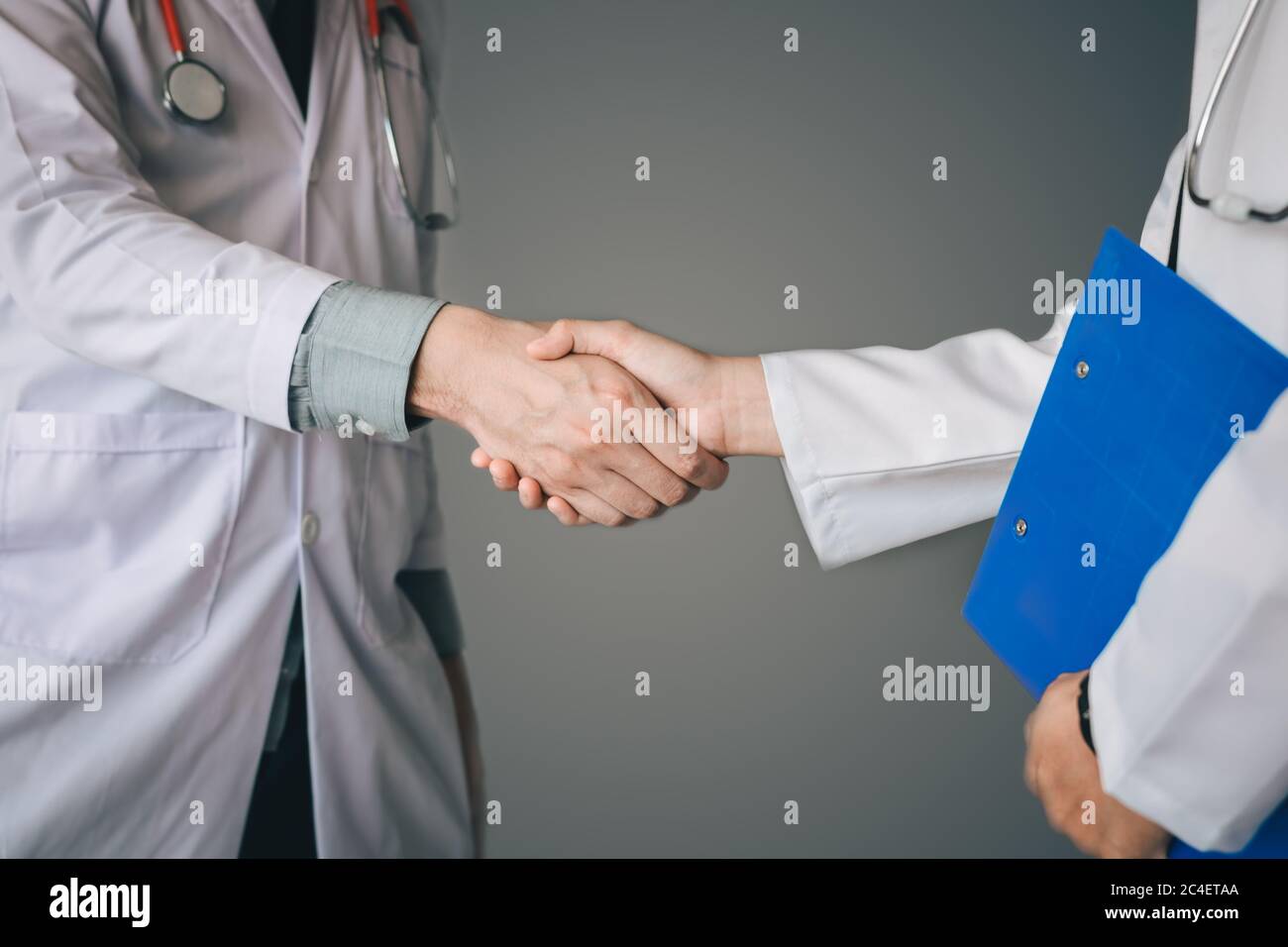 Two doctor shaking hands with working together Stock Photo - Alamy