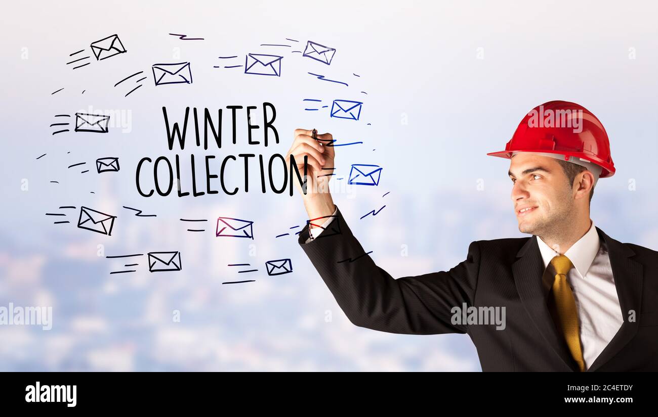 Handsome businessman with helmet drawing WINTER COLLECTION inscription ...