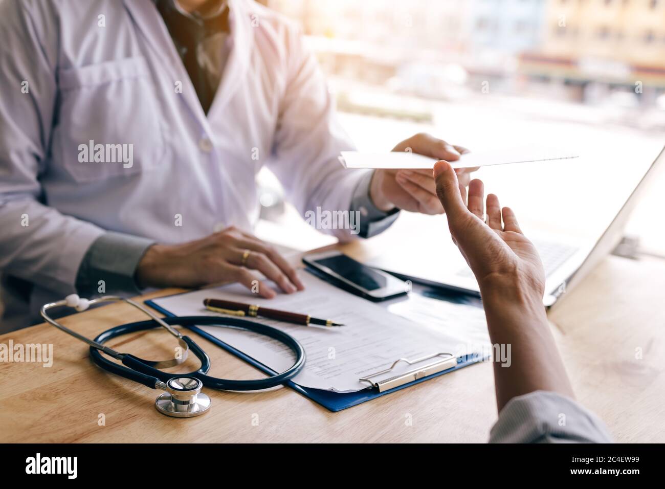 Doctor hand giving prescription document to patient Stock Photo - Alamy