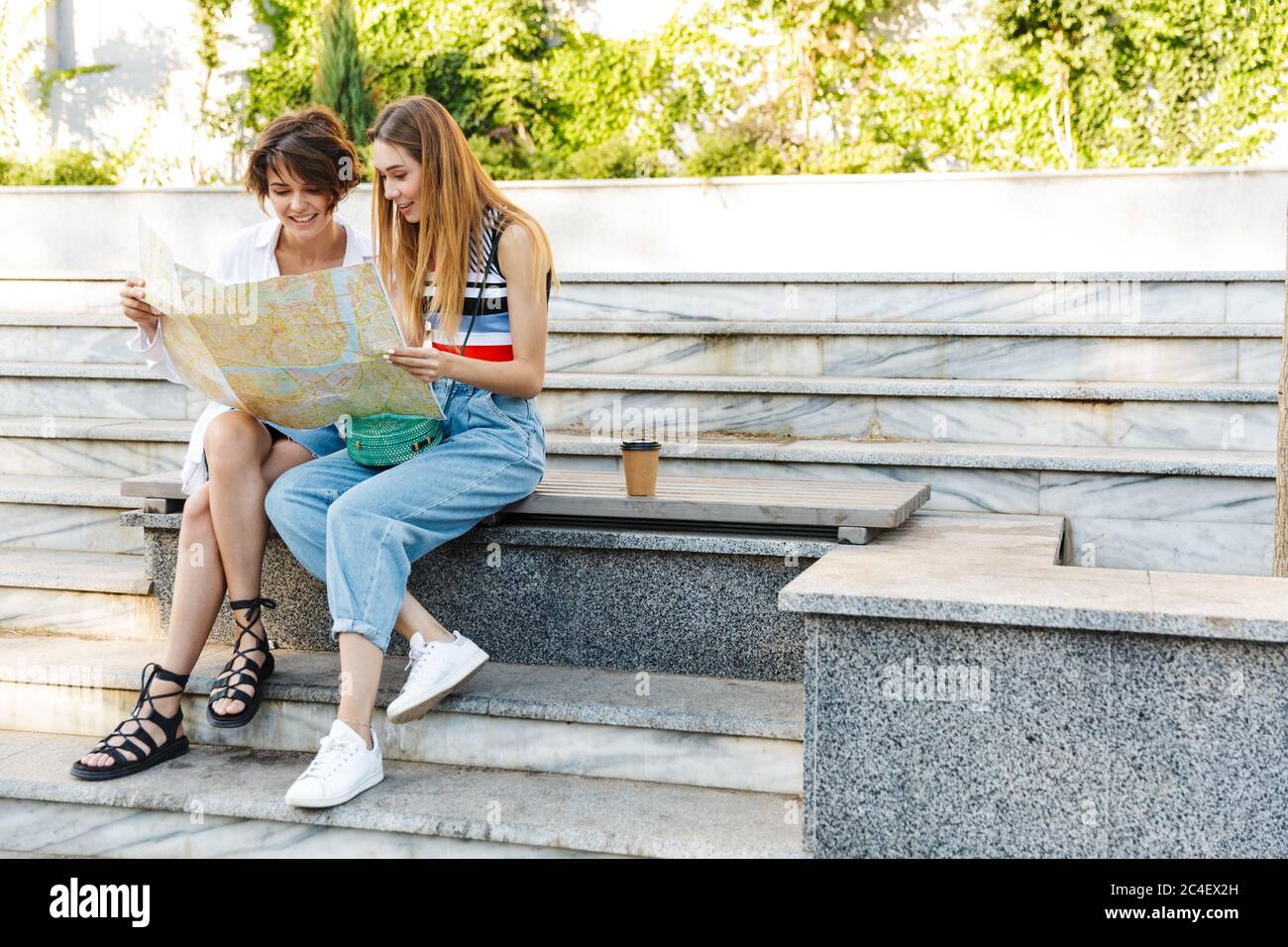 Two women sitting on stairs hi-res stock photography and images - Alamy