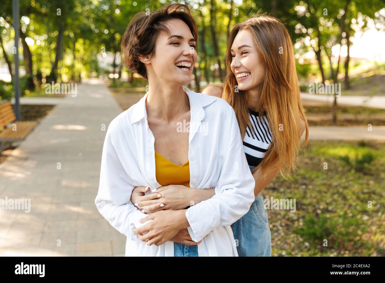 Photo of two beautiful women hugging together and laughing while ...