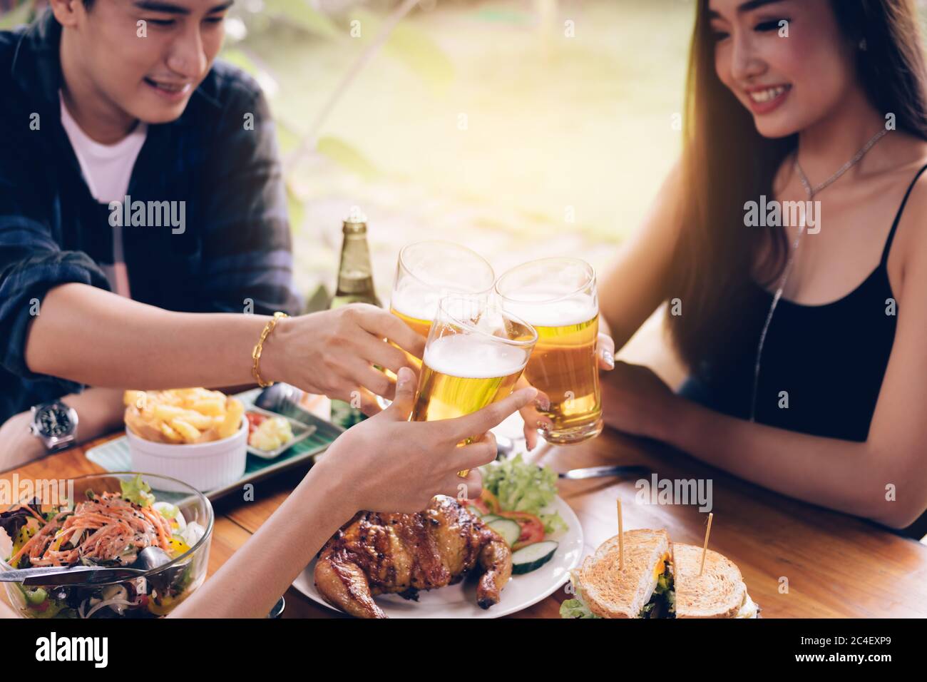 Young asian people having fun at drinking with cheering with beer at ...