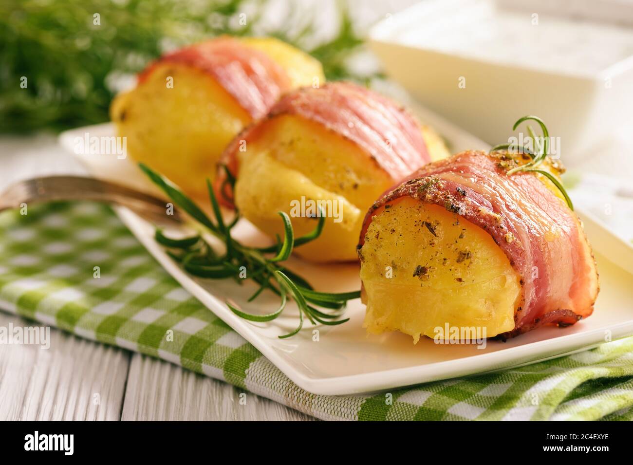 Bacon wrapped potatoes, baked with cheese Stock Photo - Alamy