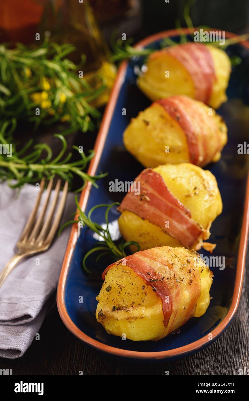 Bacon wrapped potatoes, baked with cheese Stock Photo - Alamy
