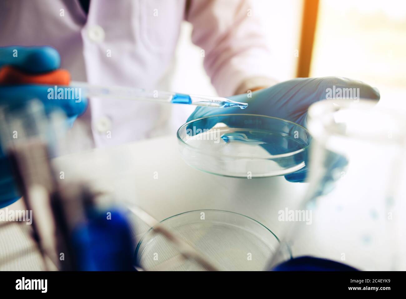 Lab technician examining doing compounds with using dropper taking a ...
