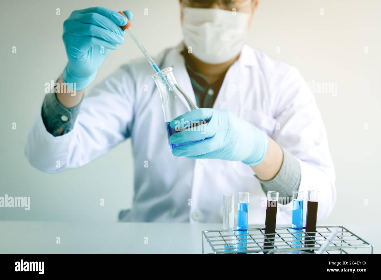 Chemist scientist conducts experiments by synthesising compounds with ...