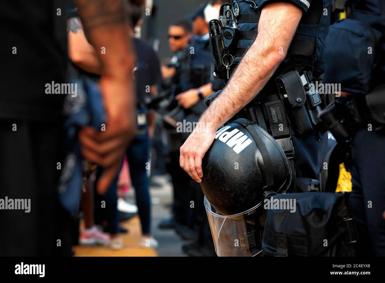 Metropolitan Police officer rests hand on helmet, part of a line ...