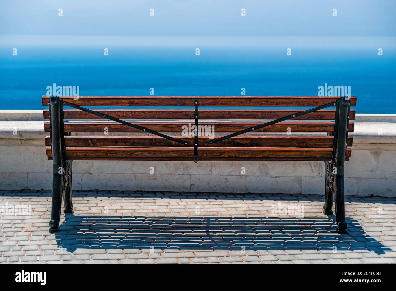 Empty bench on sea shore in the park. Sea view from mountain. Travel ...