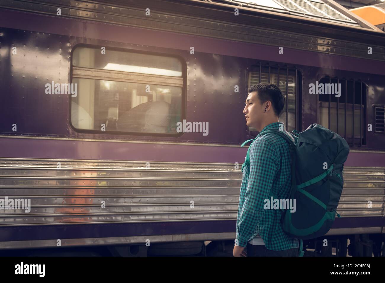 Asian man standing and looking train for travel Stock Photo - Alamy