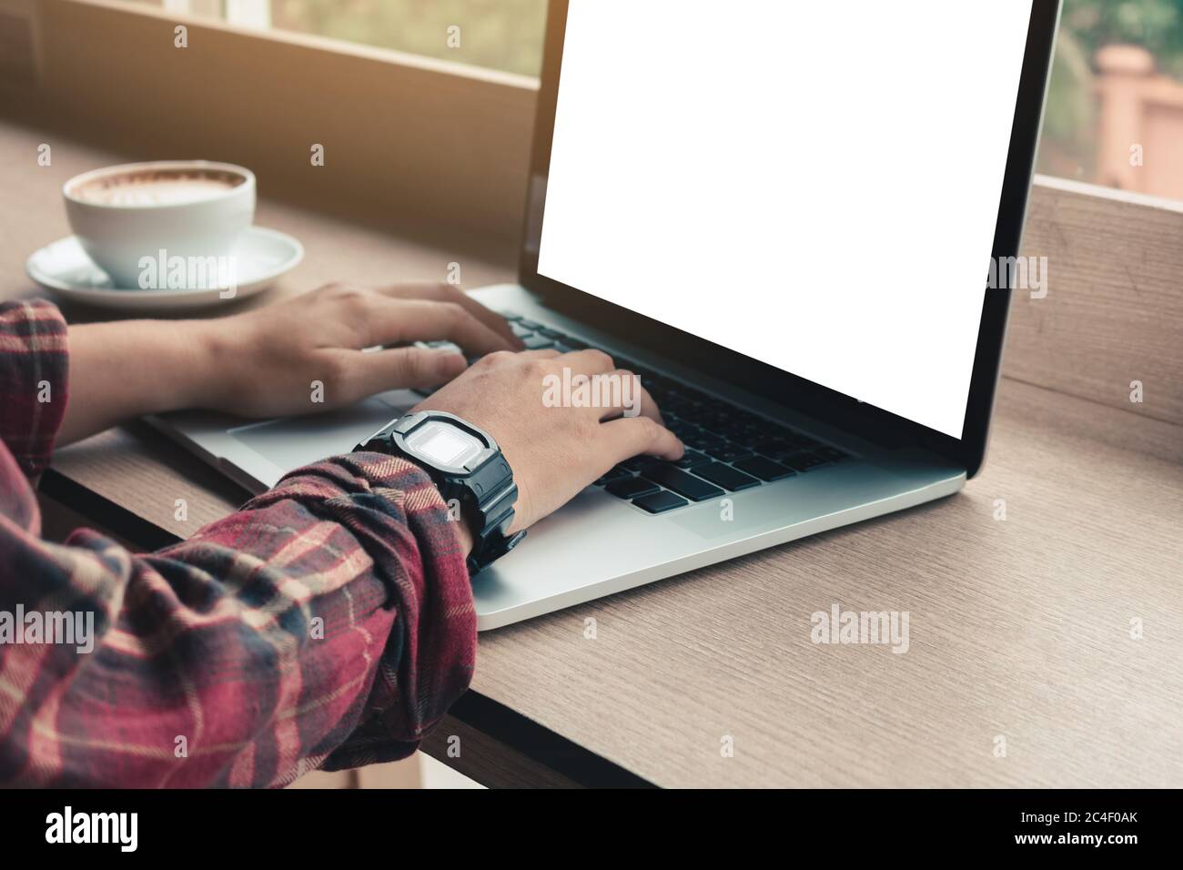 Young student typing keyboard laptop and blank screen at coffee cafe ...