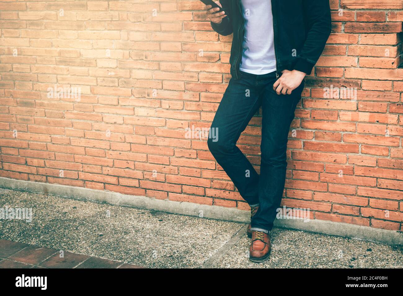 Smart man standing front a wall background Stock Photo - Alamy