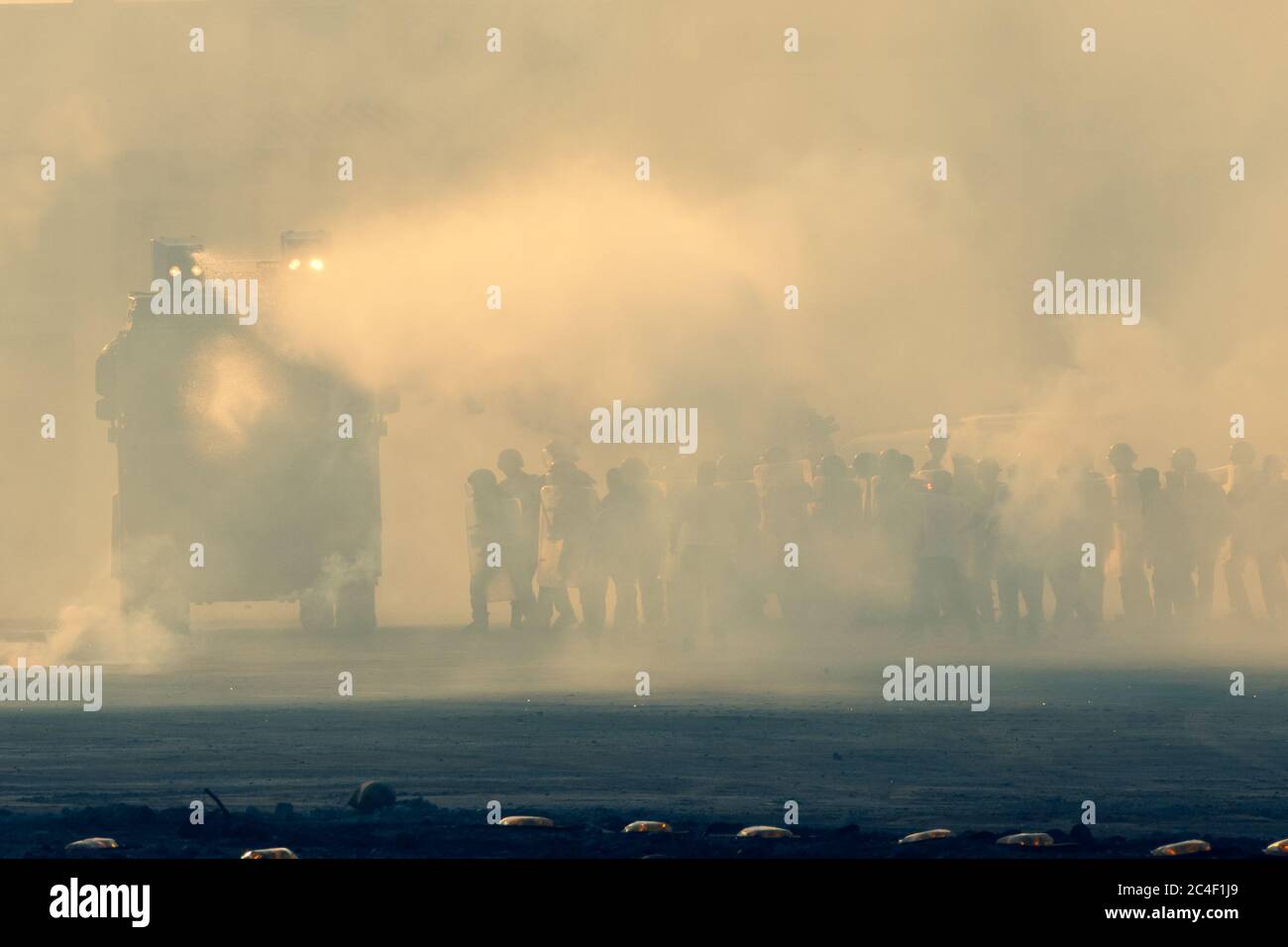 Military police riot response to a protest with tear gas, smoke, fire ...