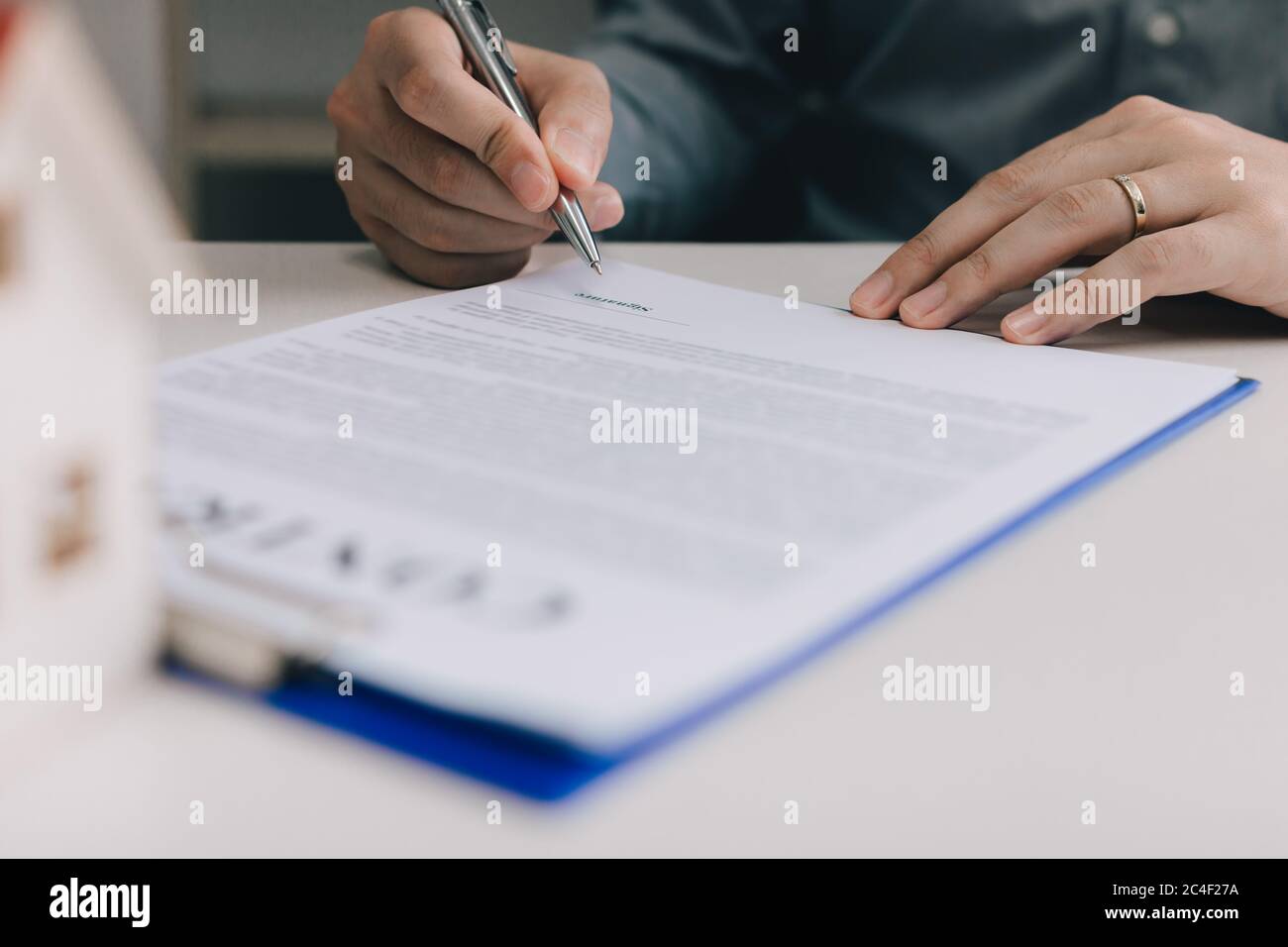 Close up hand man signing paper contract agreement for buying house ...
