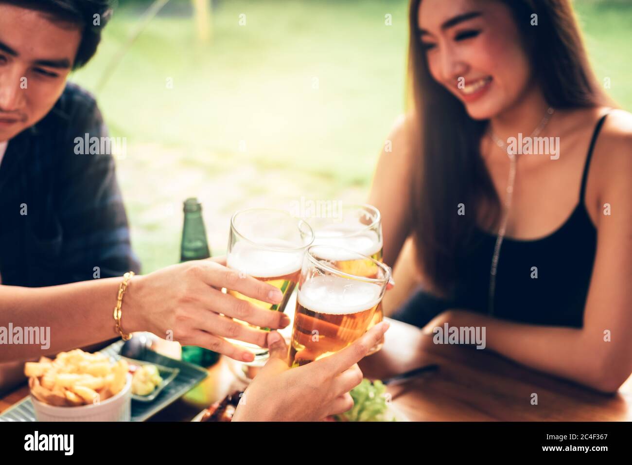 Young asian people having fun at drinking with cheering with beer at ...